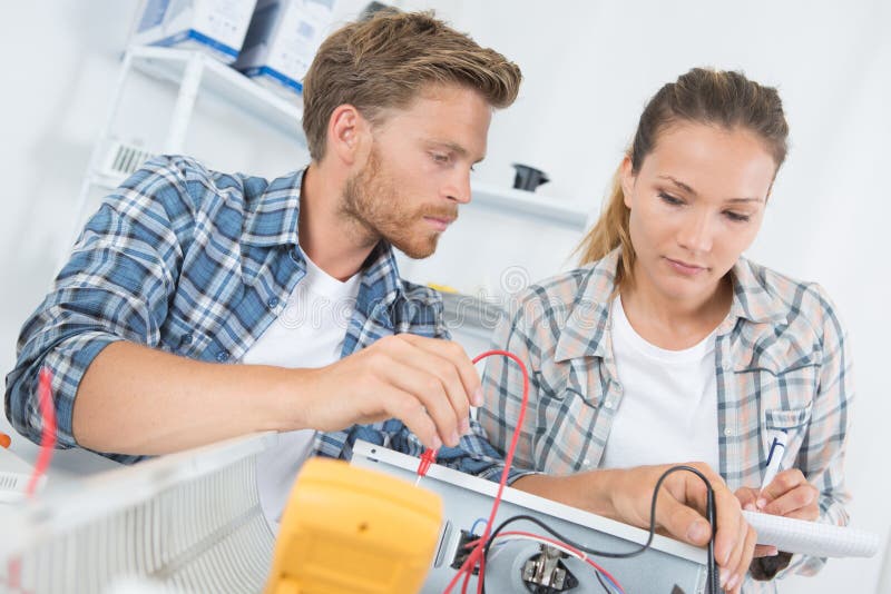 Two Technicians Testing Appliance with Multimeter Stock Image - Image ...