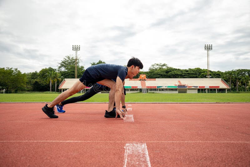 Two Teenagers Take Starting Pose for Running in Lane Stadium Stock ...