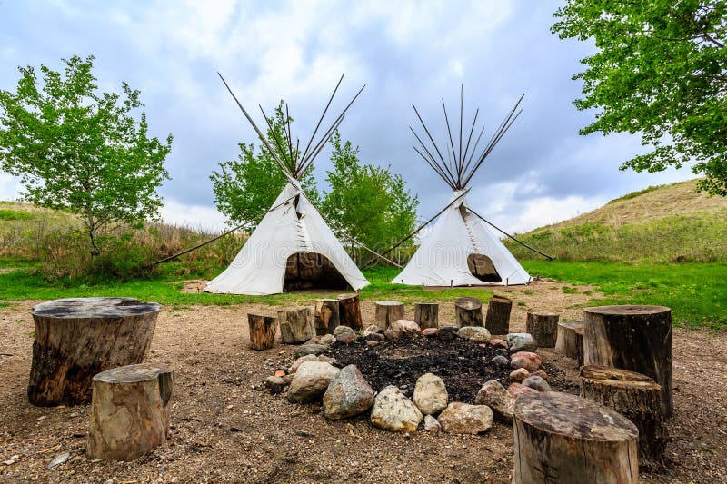 Two Teepees are Set Up in a Grassy Field with a Fire Pit in the Center ...