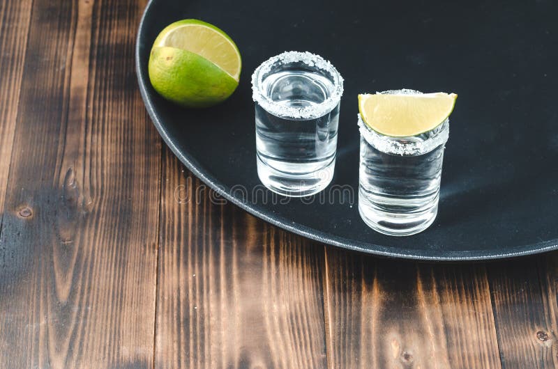 Two Tequila Shots with Lime Slices and Salt on Wooden Table/Tequila ...