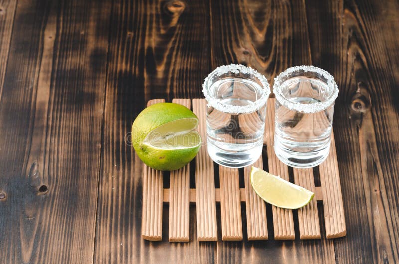 Two Tequila Shots with Lime Slices and Salt on Wooden Table/Tequila ...
