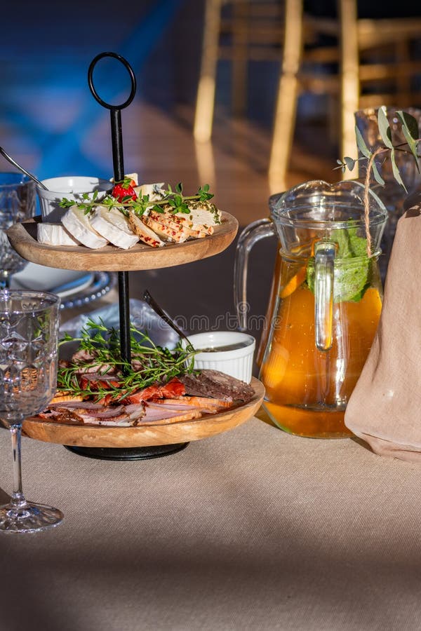 A Two-Tiered Platter of Appetizers Set on a Beige Tablecloth in an ...