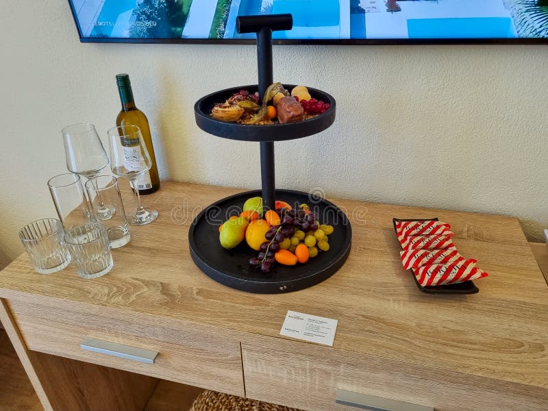 A Two-tiered Server Displays Fruit and Pastries on a Wooden Table ...