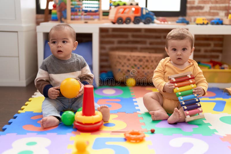 Two Toddlers Playing with Ball and Xylophone at Kindergarten Stock ...