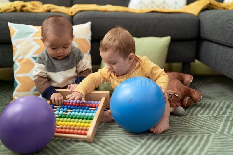 Two Toddlers Playing with Balls and Abacus Sitting on Floor at Home ...
