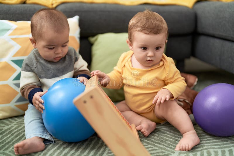 Two Toddlers Playing with Balls Sitting on Floor at Home Stock Photo ...