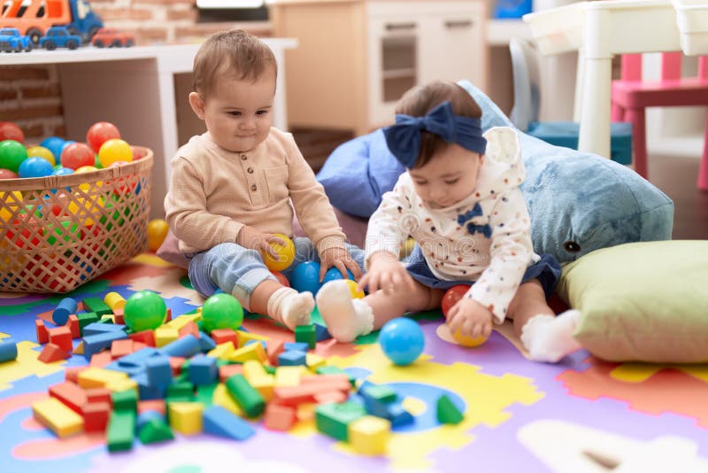 Two Toddlers Playing with Balls Sitting on Floor at Kindergarten Stock ...