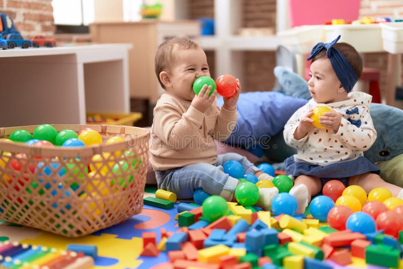 Two Toddlers Playing with Balls Sitting on Floor at Kindergarten Stock ...