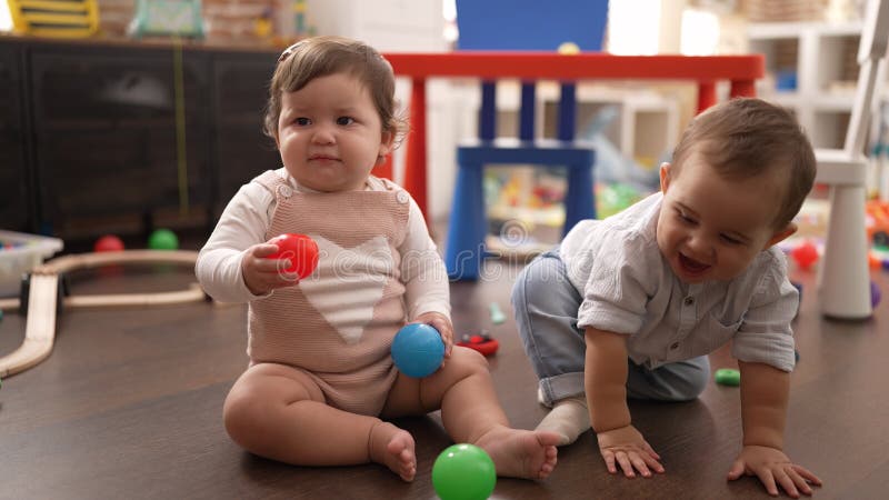 Two Toddlers Playing with Balls Sitting on Floor at Kindergarten Stock ...