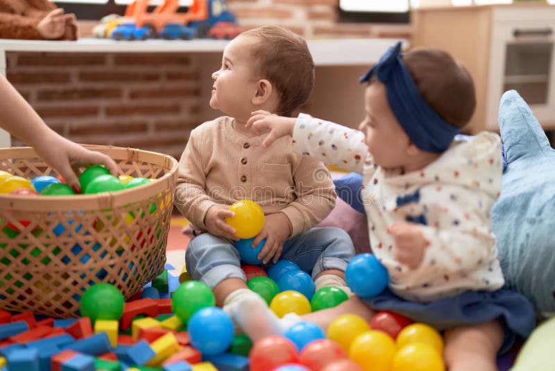 Two Toddlers Playing with Balls Sitting on Floor at Kindergarten Stock ...