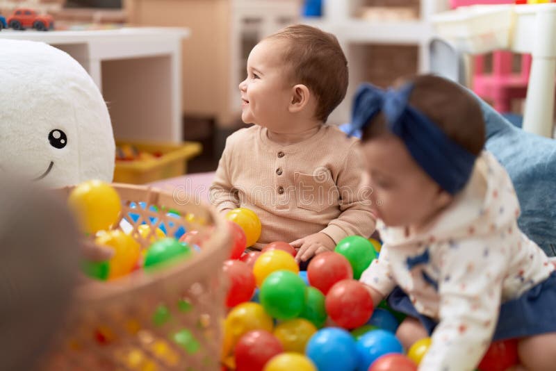Two Toddlers Playing with Balls Sitting on Floor at Kindergarten Stock ...