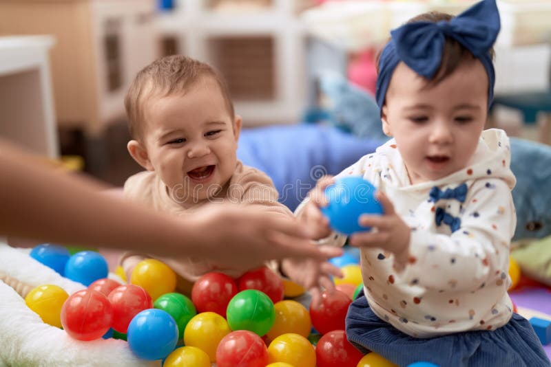 Two Toddlers Playing with Balls Sitting on Floor at Kindergarten Stock ...