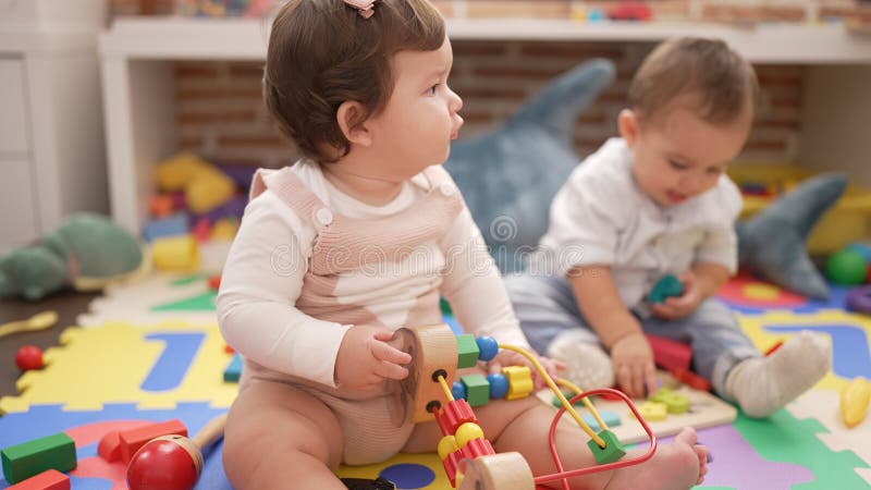 Two Toddlers Playing with Toys Sitting on Floor at Kindergarten Stock ...
