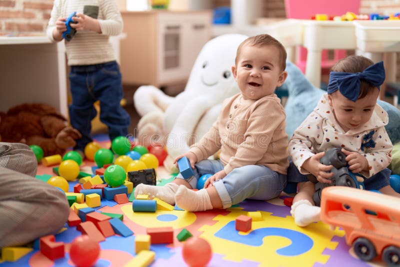 Two Toddlers Playing with Toys Sitting on Floor at Kindergarten Stock ...