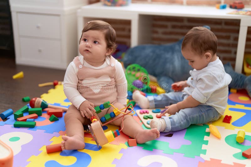 Two Toddlers Playing with Toys Sitting on Floor at Kindergarten Stock ...