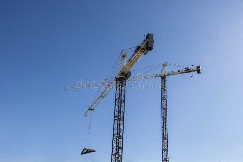 Two Tower Cranes on Construction Sight Lifting Building Materials ...