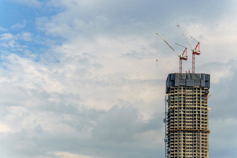 Two Tower Cranes Rise Above a Modern Residential Building Under ...