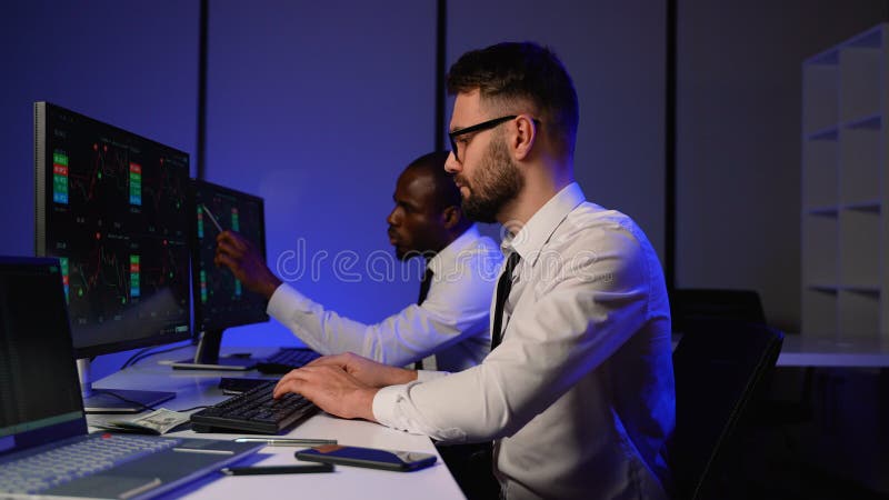 Two Traders Analyzing Stock Market Data on Multiple Screens Stock ...