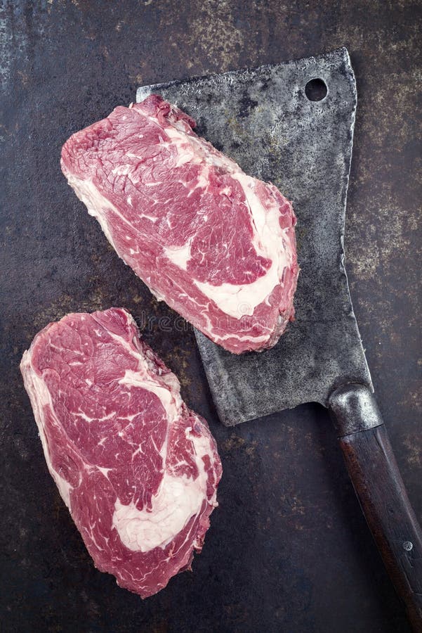 Two Traditional Raw Angus Entrecote Beef Steaks on a Rustic Old Board ...