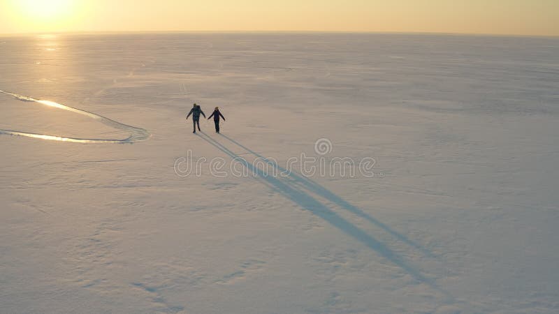 The Two Travelers Walking through the Arctic Icy Field. Stock Photo ...
