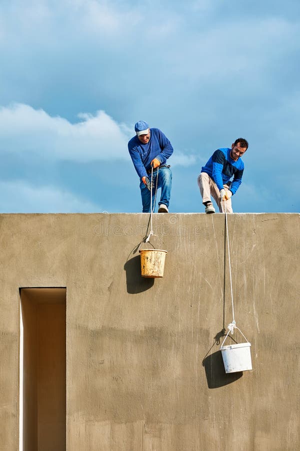 Two Turkish Construction Workers Working at the Top of a Building and ...