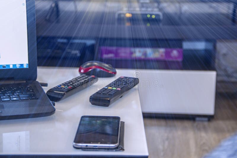 Two TV Remotes in the Background of a Room with a Laptop and a ...