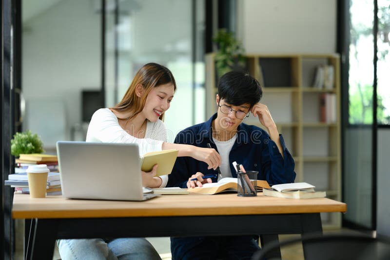 Two University Students Sharing Ideas while Studying Together in a Library. Education Concept ...
