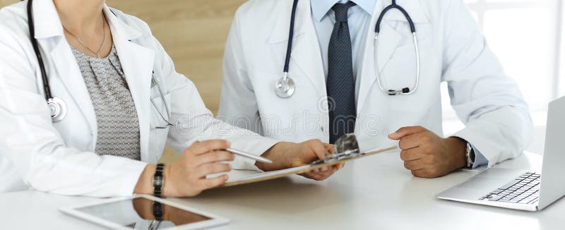 Two Unknown Doctors Discussing Treatment Problems while Sitting at the ...