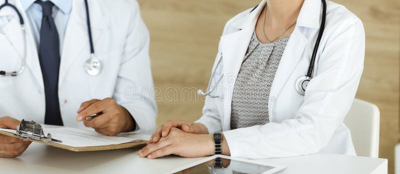 Two Unknown Doctors Discussing Treatment Problems while Sitting at the ...