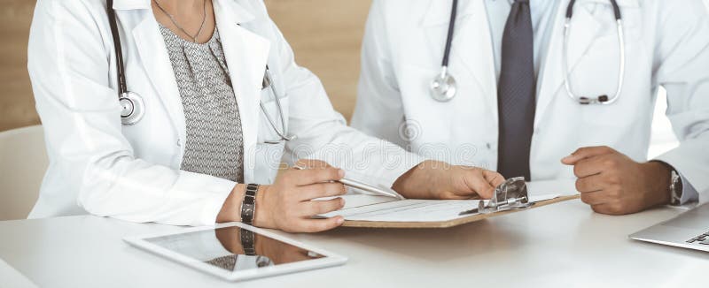 Two Unknown Doctors Discussing Treatment Problems while Sitting at the ...