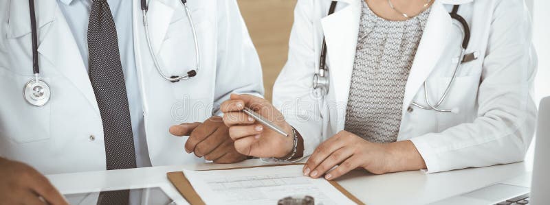 Two Unknown Doctors Discussing Treatment Problems while Sitting at the ...