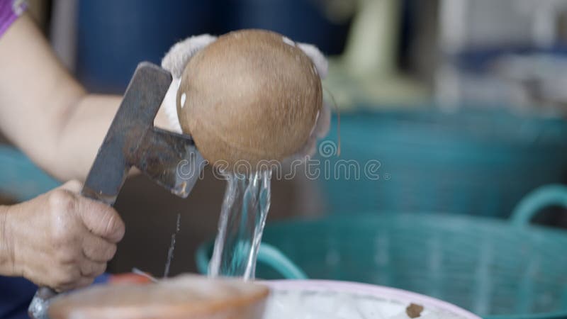 Two Unprotected Hands Opening a Coconut with an Ax and Getting Its Coco ...