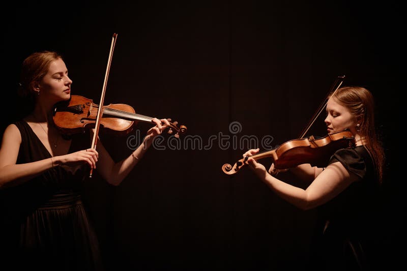 Two Violin Artists Performing Concerto on Black Background Stock Image ...