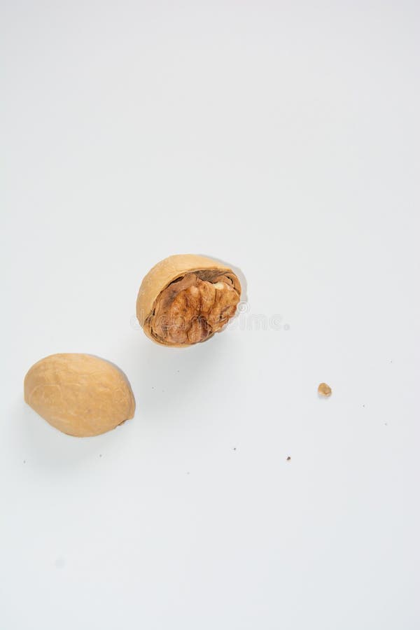 Two Walnuts, One Intact and One Open, Placed Naturally on a White ...