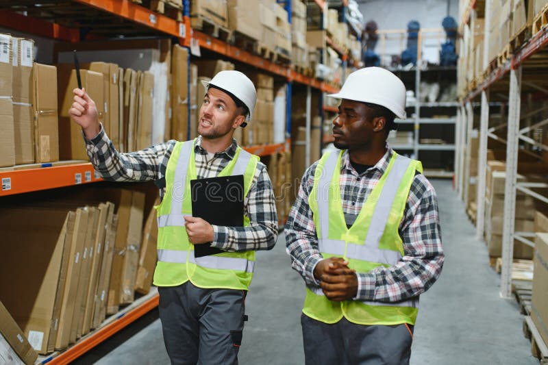 Two Warehouse Workers Checking and Controlling Boxes in Warehouse ...