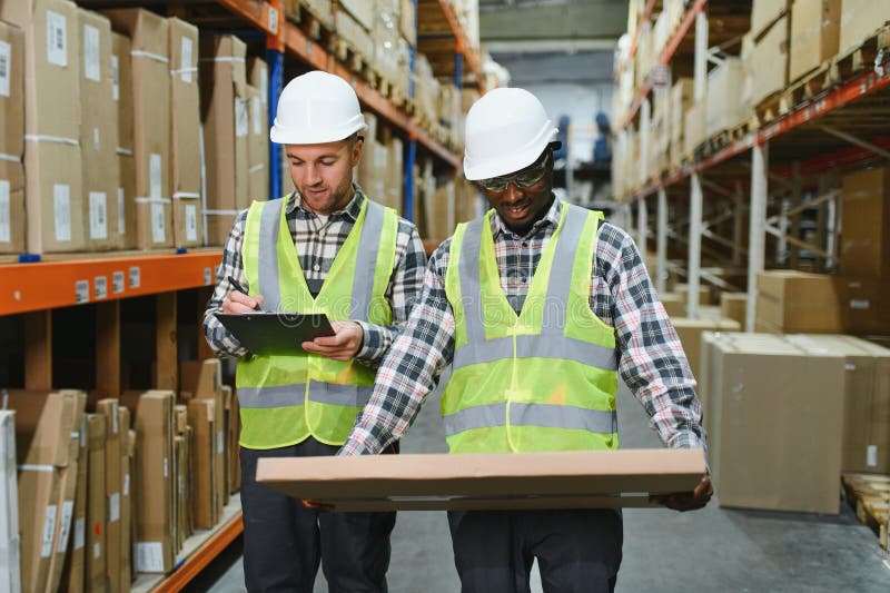 Two Warehouse Workers are Walking through the Facility, Engaged in ...