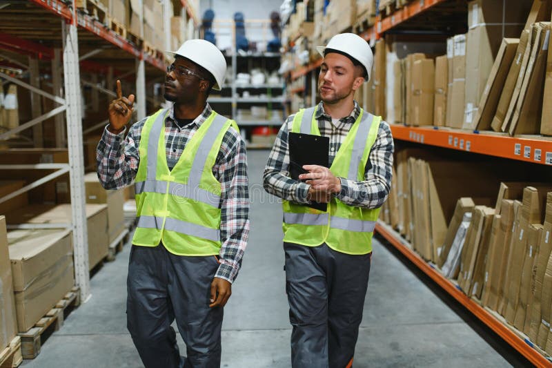 Two Warehouse Workers are Walking through the Facility, Engaged in ...
