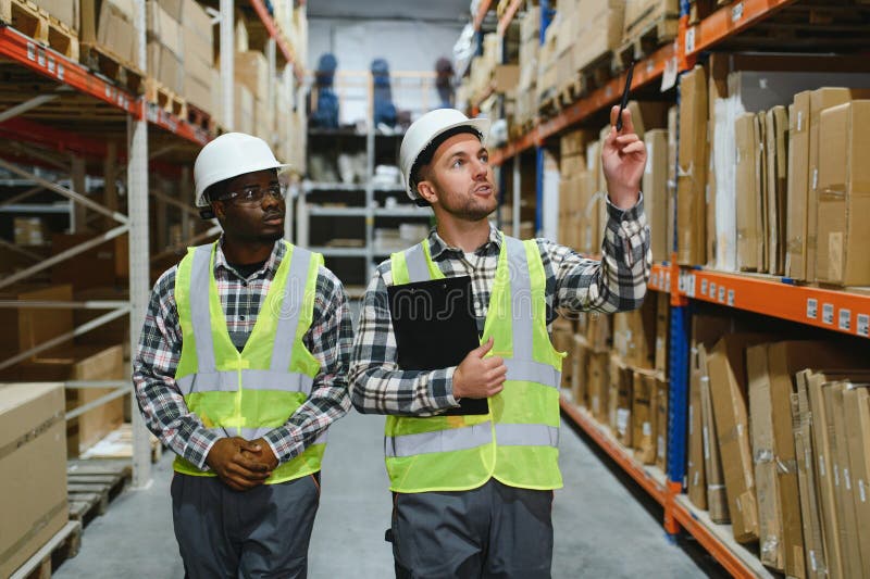 Two Warehouse Workers are Walking through the Facility, Engaged in ...