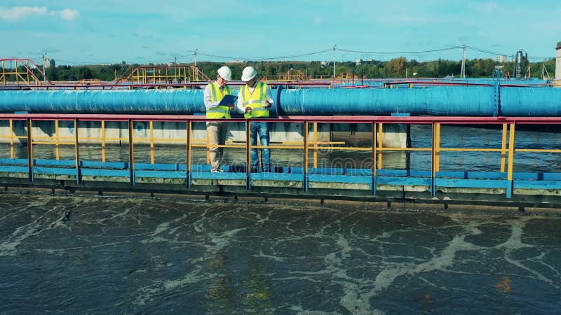 Wastewater Operator Monitoring a Sewage Treatment System Using His ...