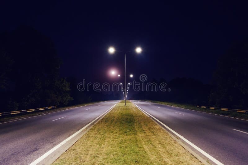 A Two Way Road is Illuminated by the Light Post Stock Image - Image of ...