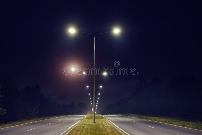A Two Way Road is Illuminated by the Light Post Stock Image - Image of ...