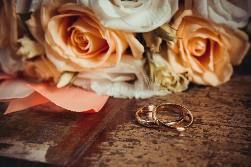 Two Wedding Rings and a Bouquet of Orange and White Roses. Stock Image ...