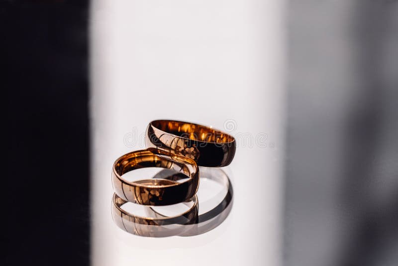 Two Wedding Rings Laying on Flat Mirror Stock Photo - Image of spray ...