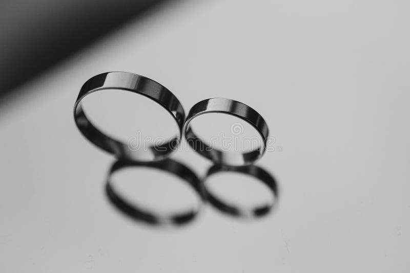 Two Wedding Rings Laying on a Mirror. Black and Stock Photo - Image of ...