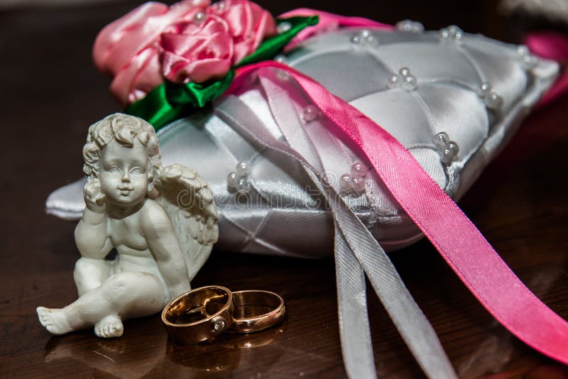 Two Wedding Rings Lie on the Table.a Sculpture Angel. Stock Photo ...