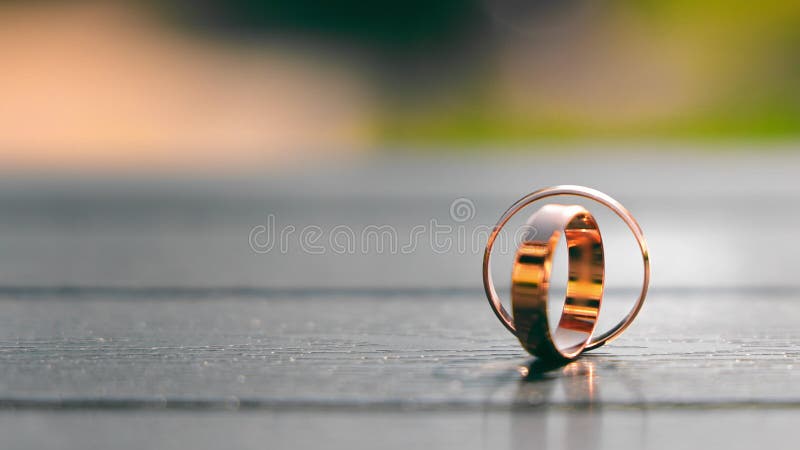 Two Wedding Rings Standing Together on a Wooden Surface, the Image ...