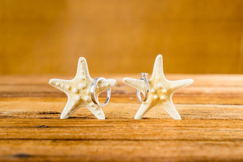 Two Wedding Rings with Two Starfish on Wooden Table Stock Photo - Image ...
