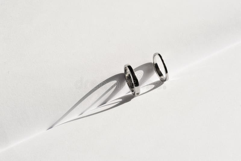 Two Wedding Rings on a White Background with a Shadow in the Shape of ...