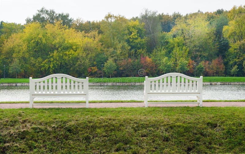 Two White Benches in the Park in Autumn by the Pond Stock Photo - Image ...