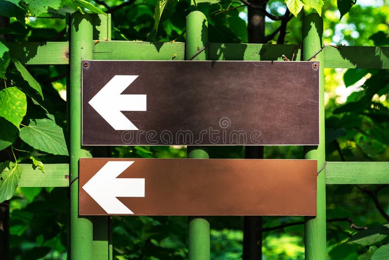 Two White Directional Arrow Road Sign Point To the Left in the Park ...